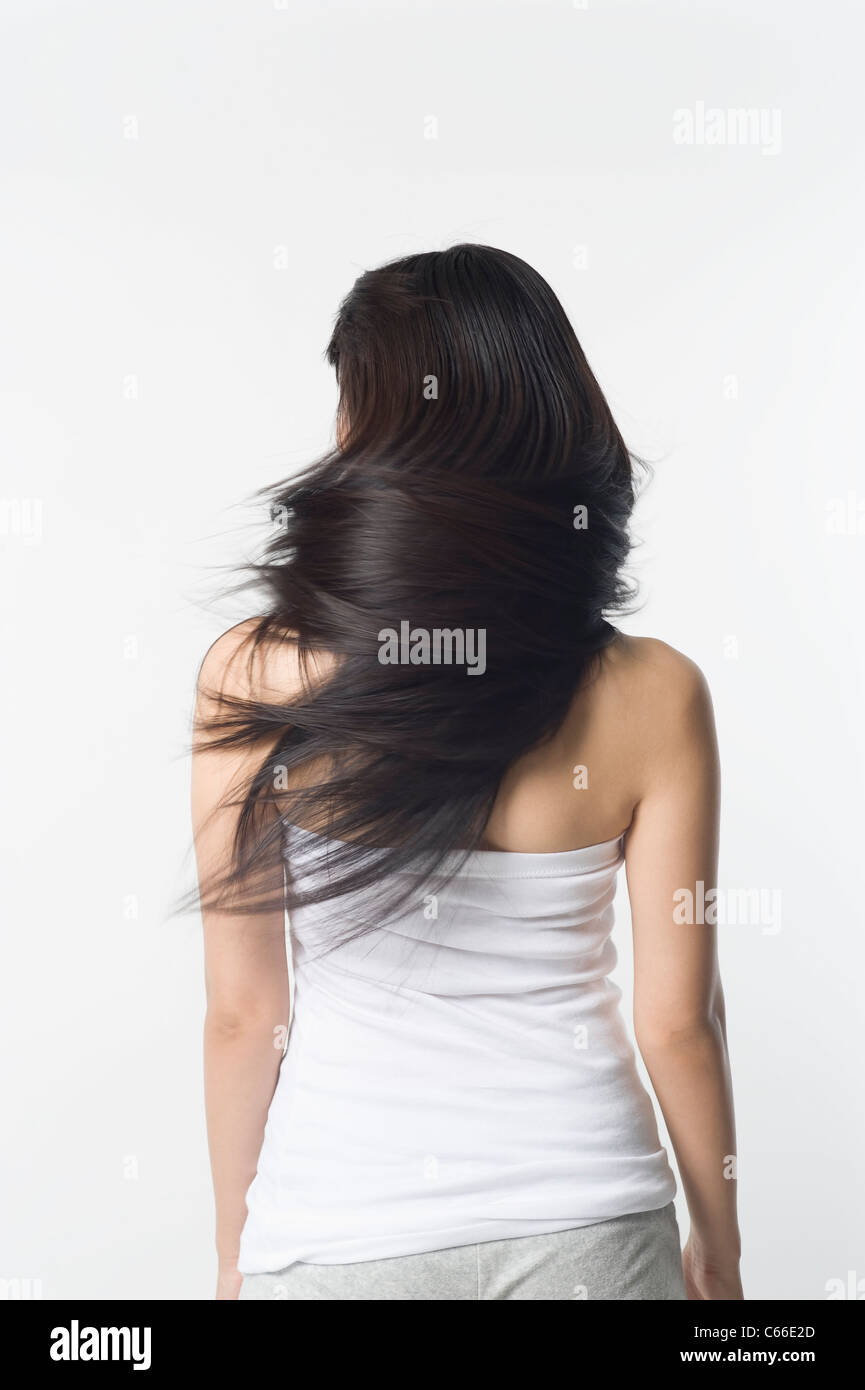 Rear View of Woman Swinging Long Hair Stock Photo - Alamy