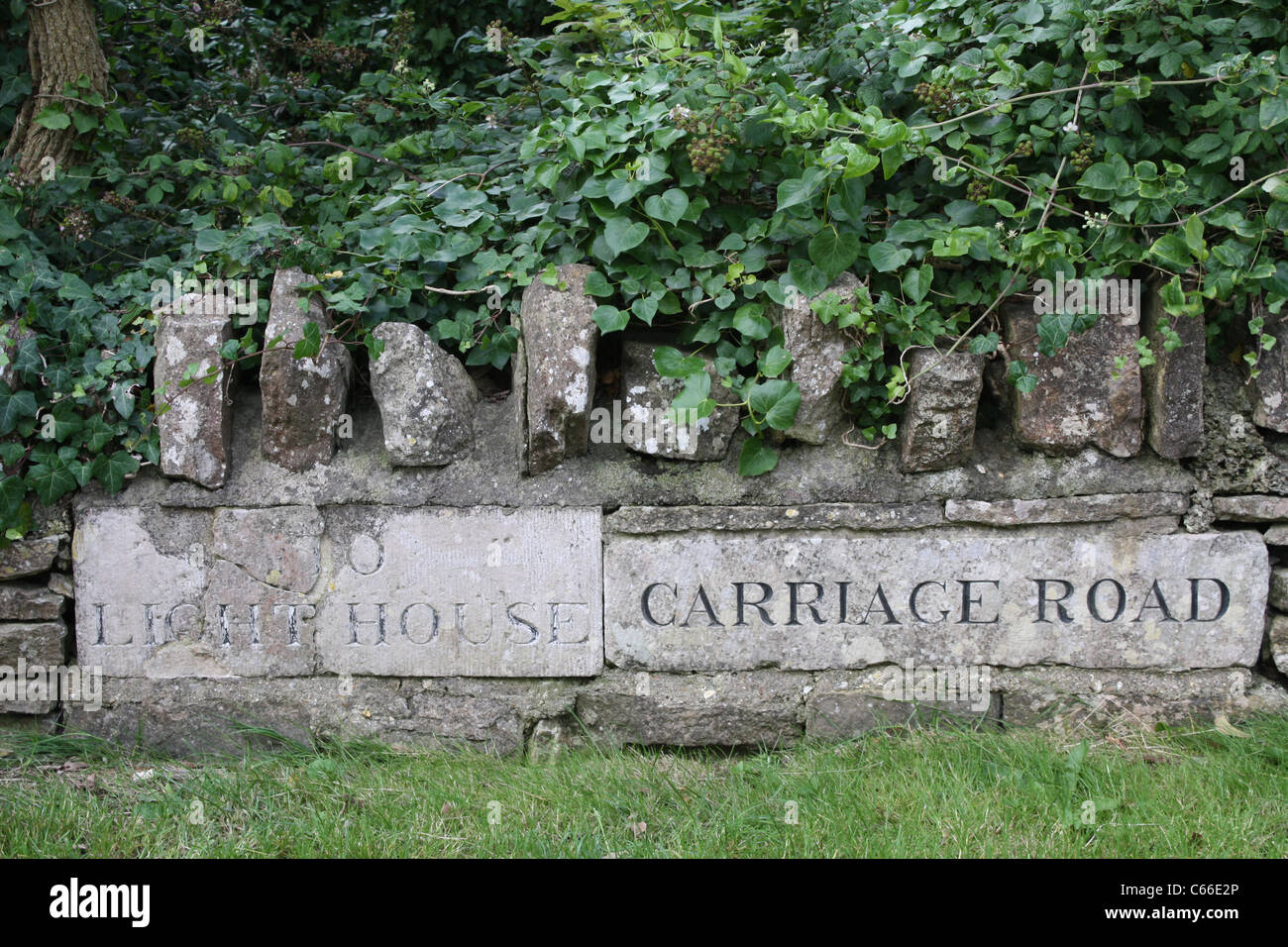 Old stone sign set in dry stone wall. Swanage Durlson Country Park ...