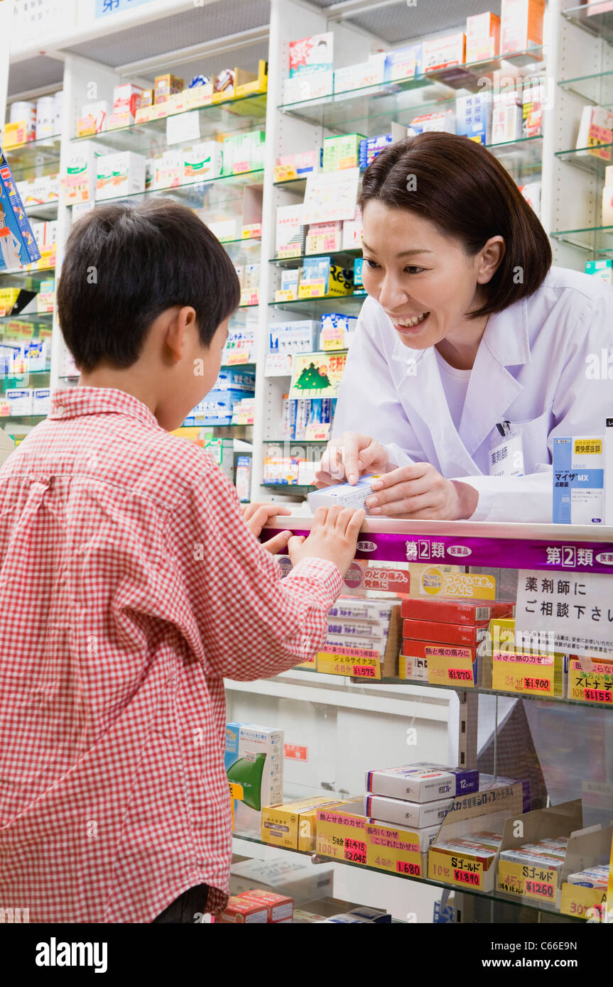 Pharmacist Talking to Boy at Drugstore Stock Photo - Alamy