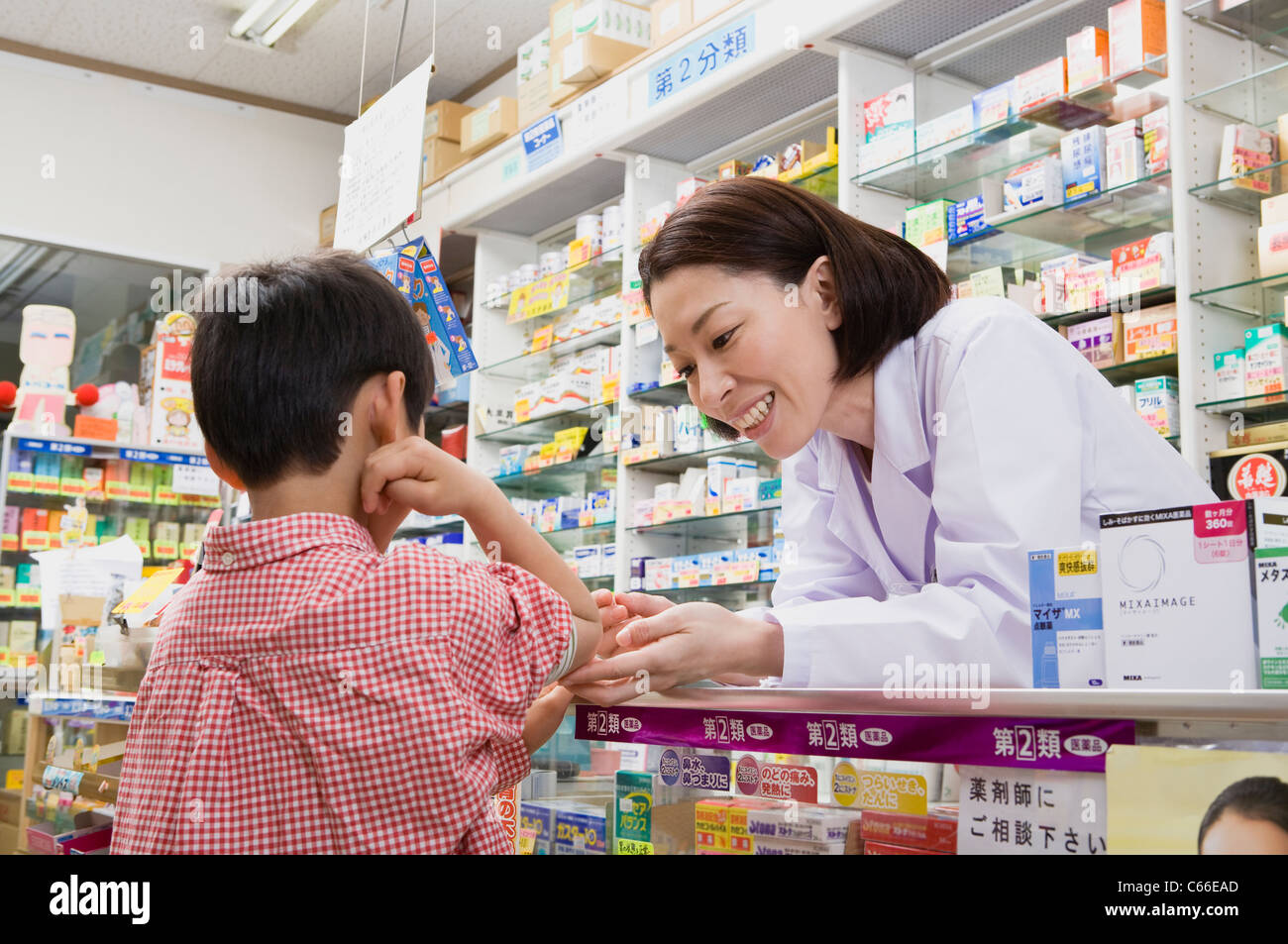 Pharmacist Looking Over Boy's Elbow Stock Photo - Alamy