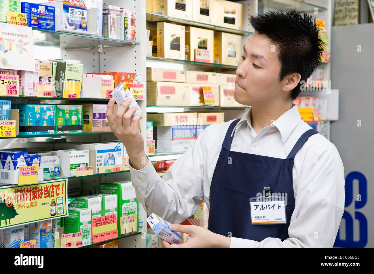 Clerk of Drugstore Holding and Looking Merchandise Stock Photo - Alamy