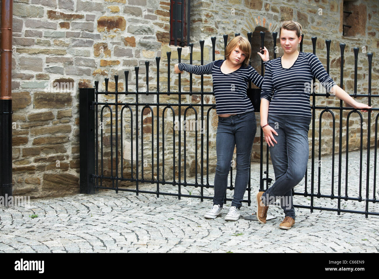 Two girls standing in front of closed gate Stock Photo - Alamy