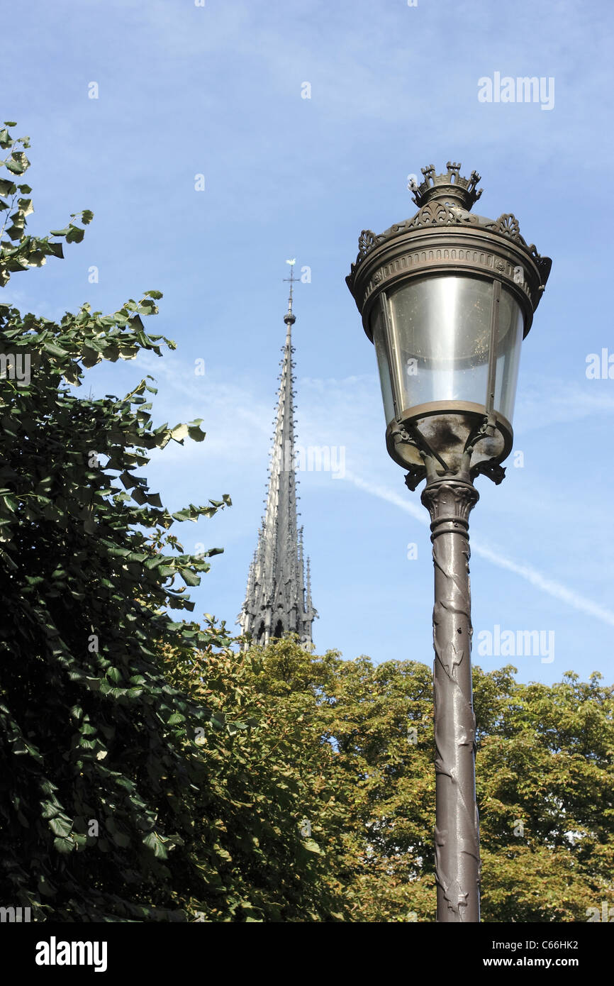 A Parisian lamp post with the spire of Notre Dame Cathedral in the ...