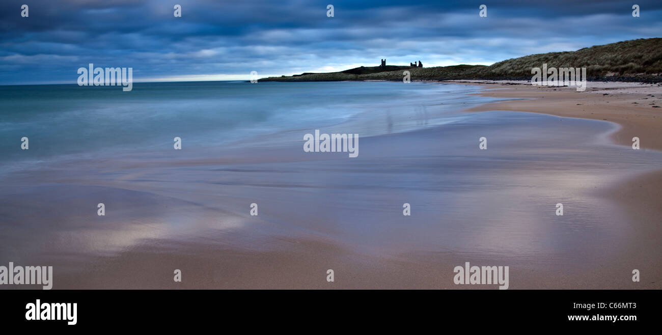 Reflective beach with Dunstanburgh Castle in Background Stock Photo - Alamy