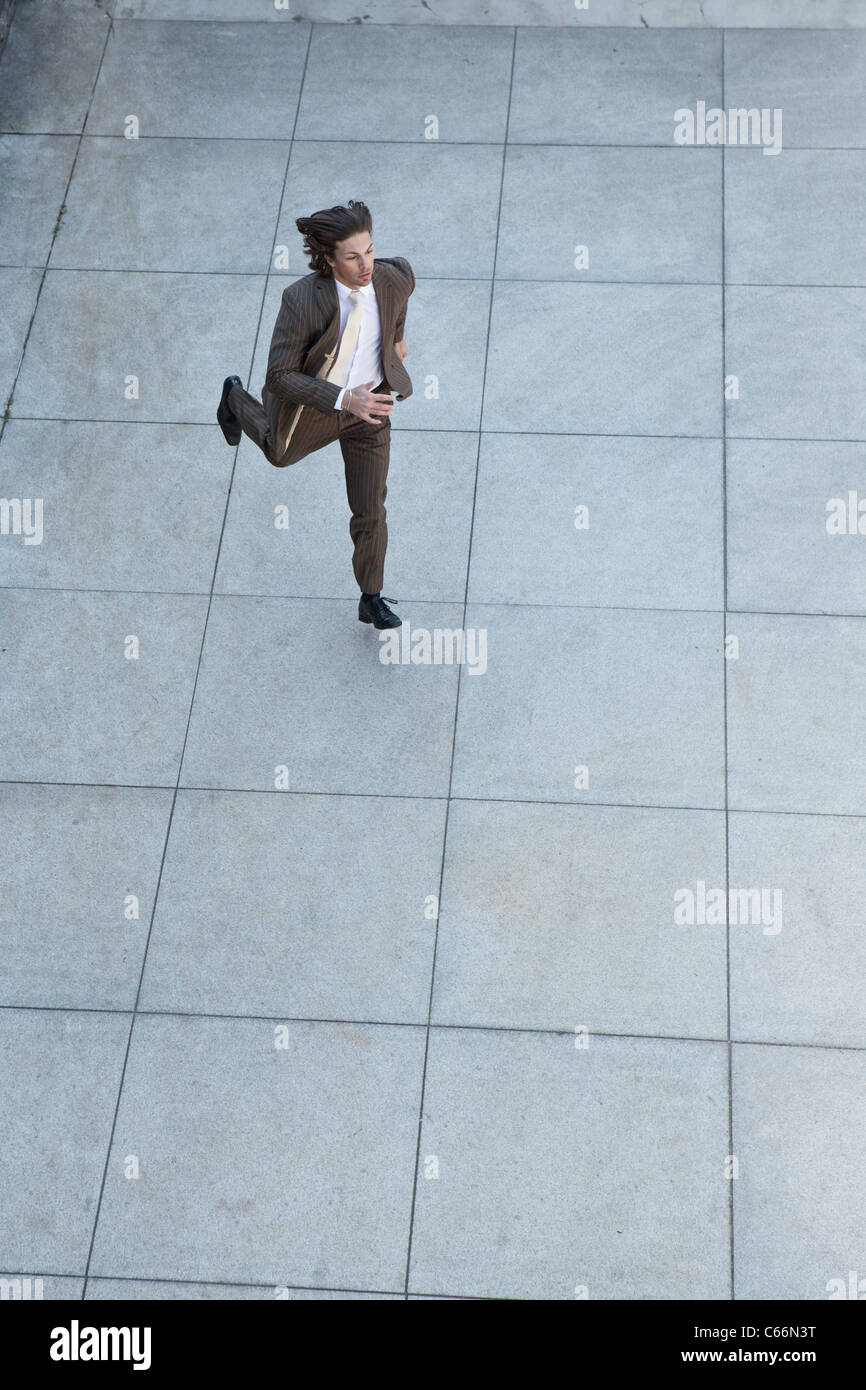 Businessman running in square Stock Photo - Alamy