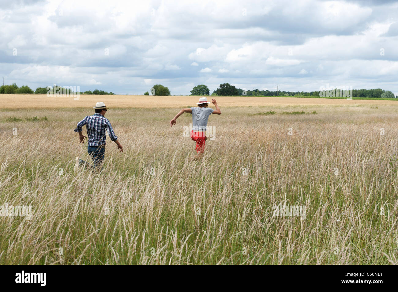 Men running in wheat field Stock Photo - Alamy