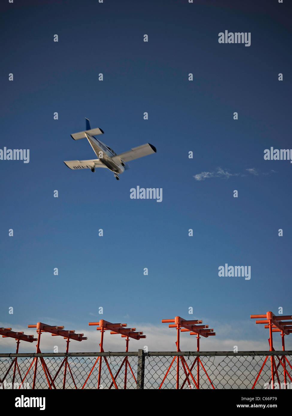 Airplane flying over fence Stock Photo - Alamy