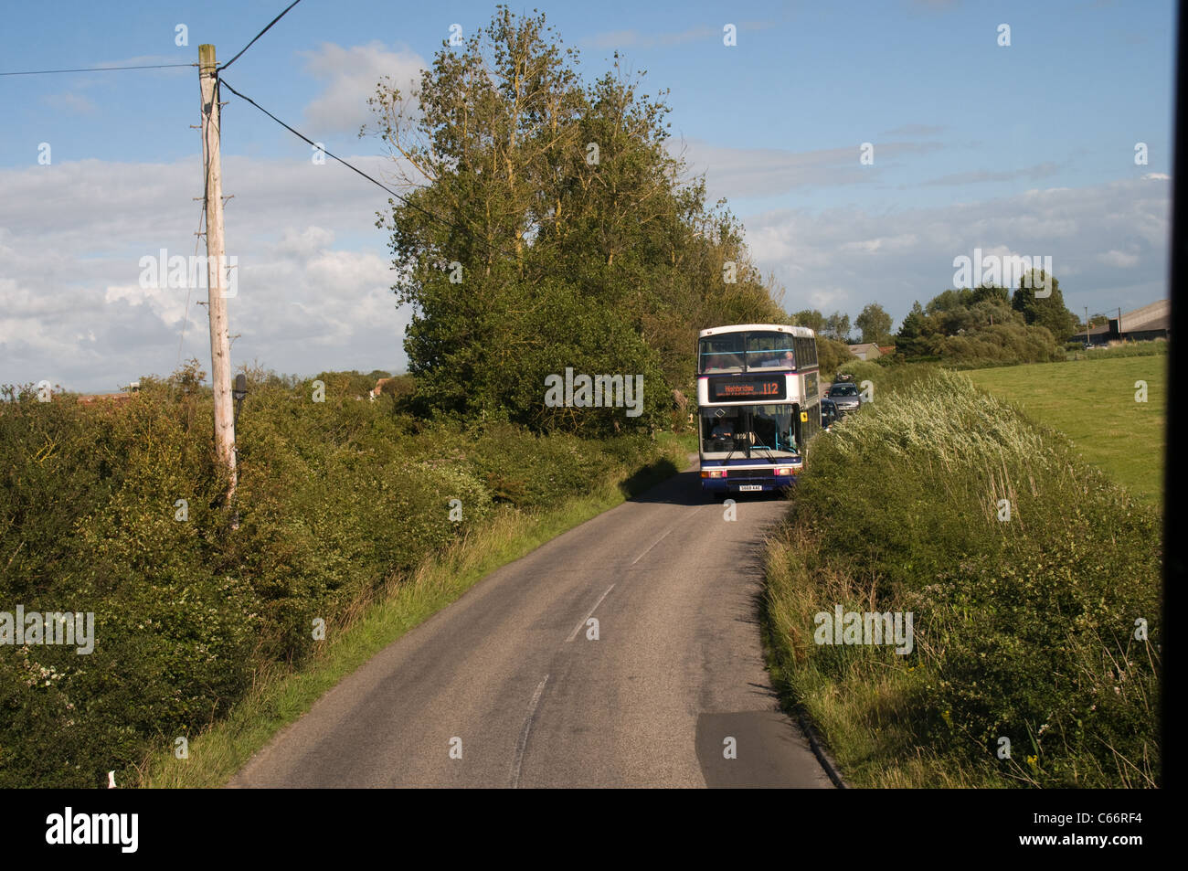 A double deck bus traveling down a country road has pulled over to the ...