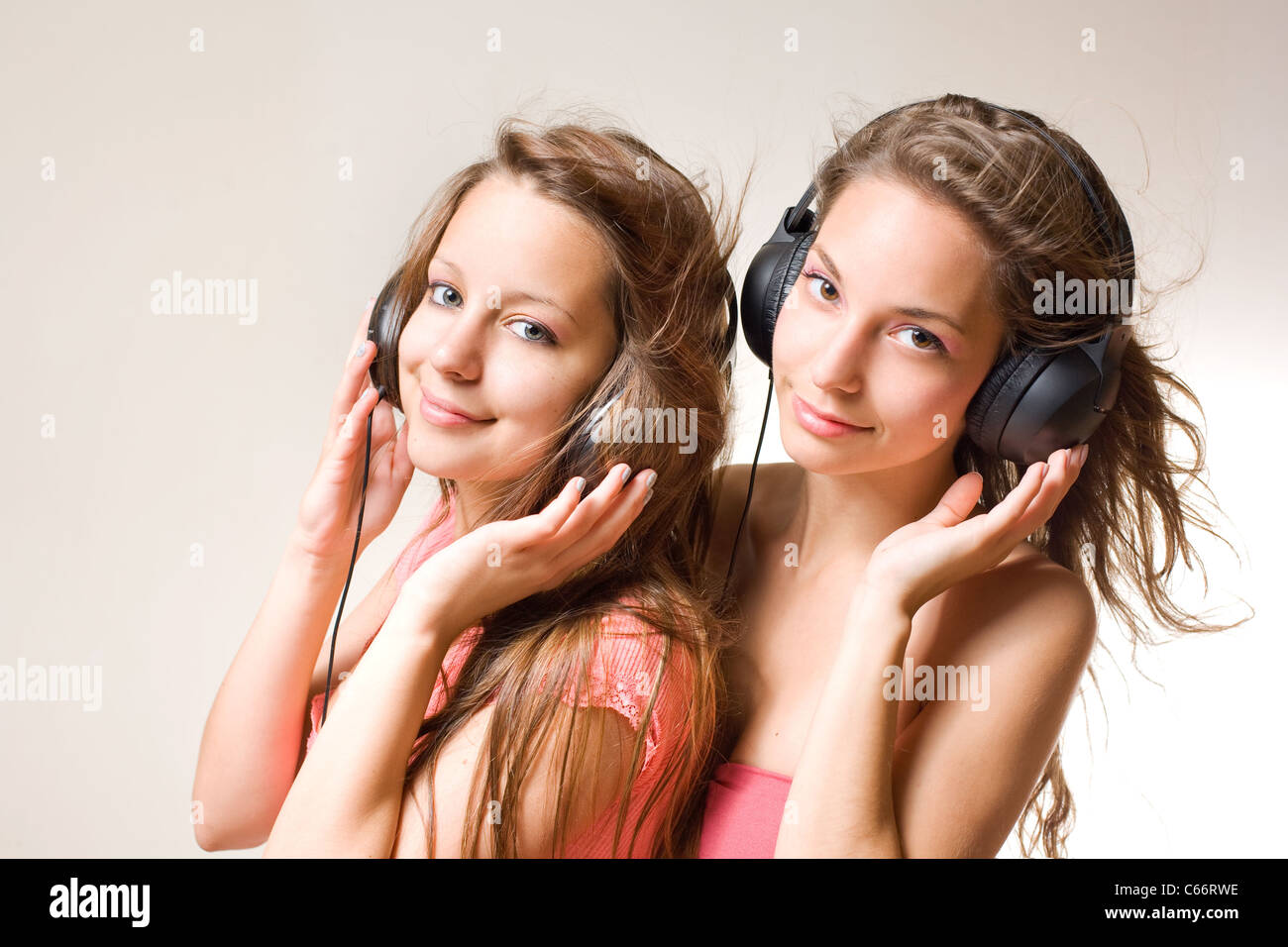 Share the music, two gorgeous brunette girls listening to music in ...