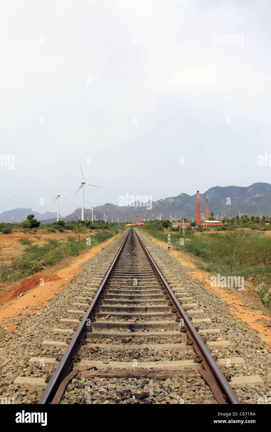 Railway track in wind mill background Stock Photo - Alamy