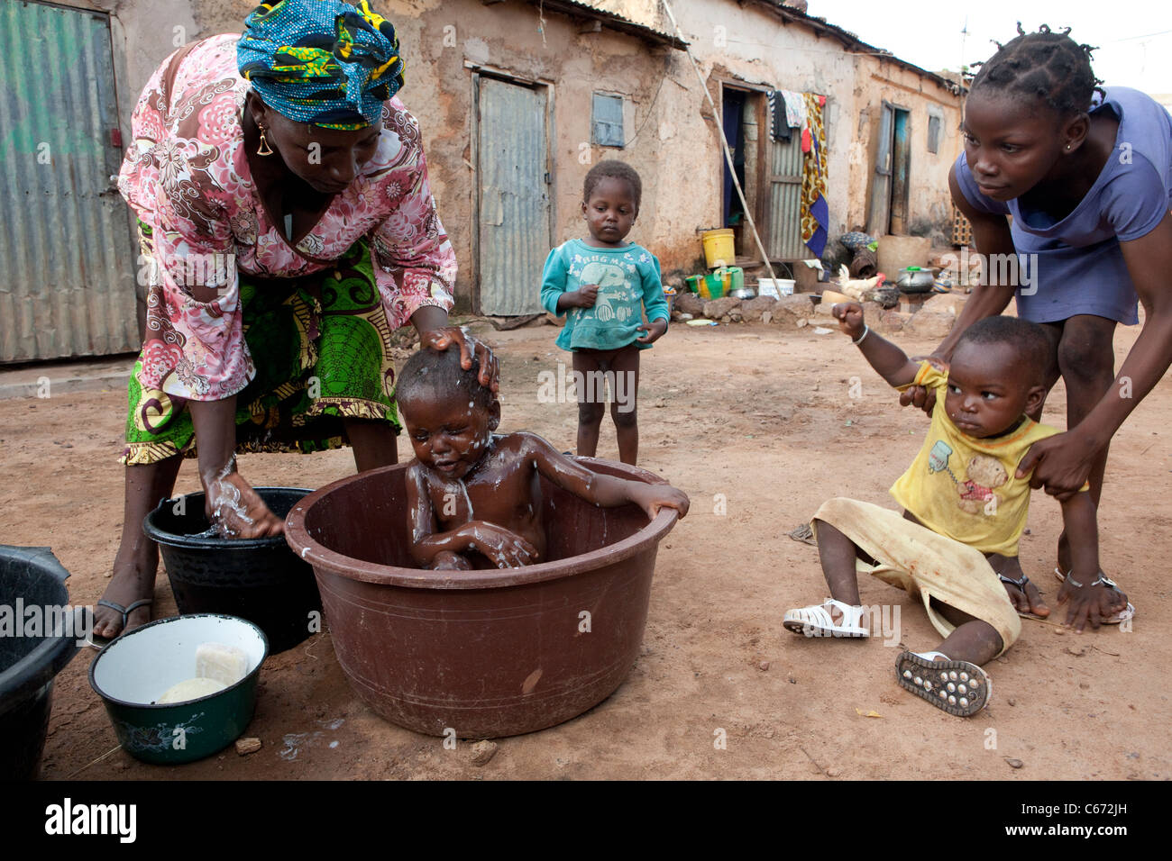 A mother bathes her child in a slum in Bamako, Mali, West Africa Stock ...
