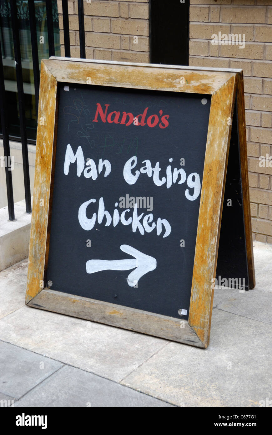 Blackboard sign outside a restaurant reading "man eating chicken Stock ...