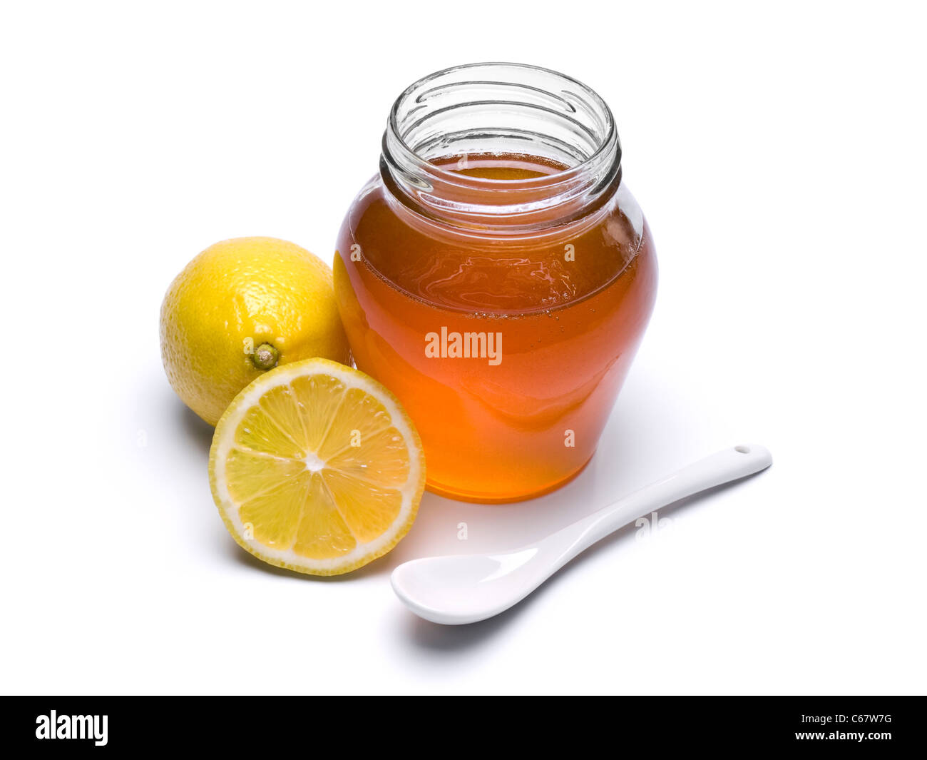 A jar of honey, lemons and spoon. Isolated on white background Stock ...