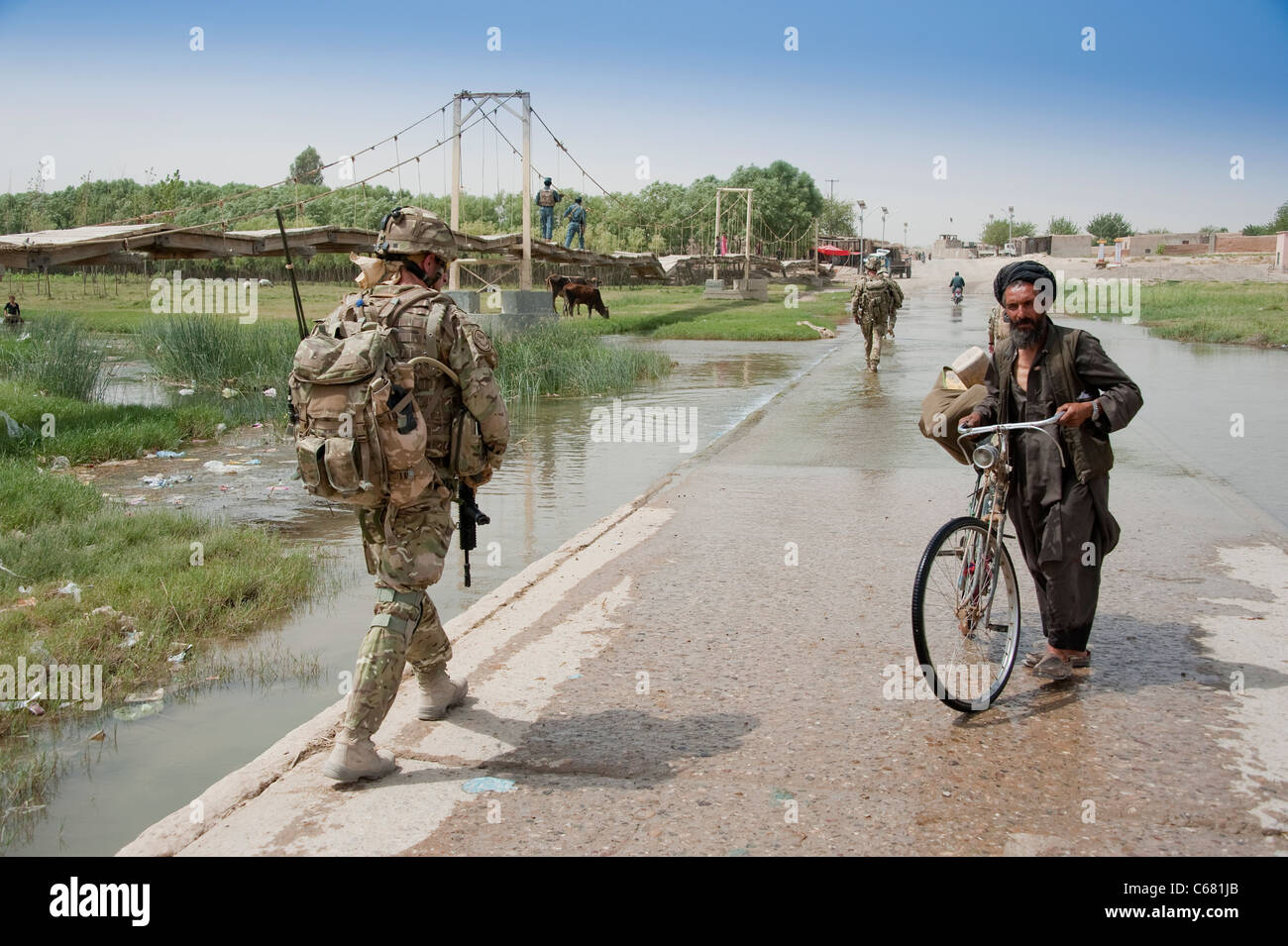 Soldier and Afghan man meet at ford crossing in Helmand Afghanistan ...