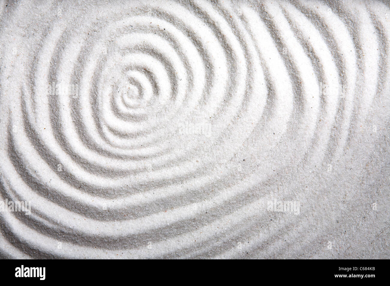 A background patter of a swirl in white sand Stock Photo - Alamy