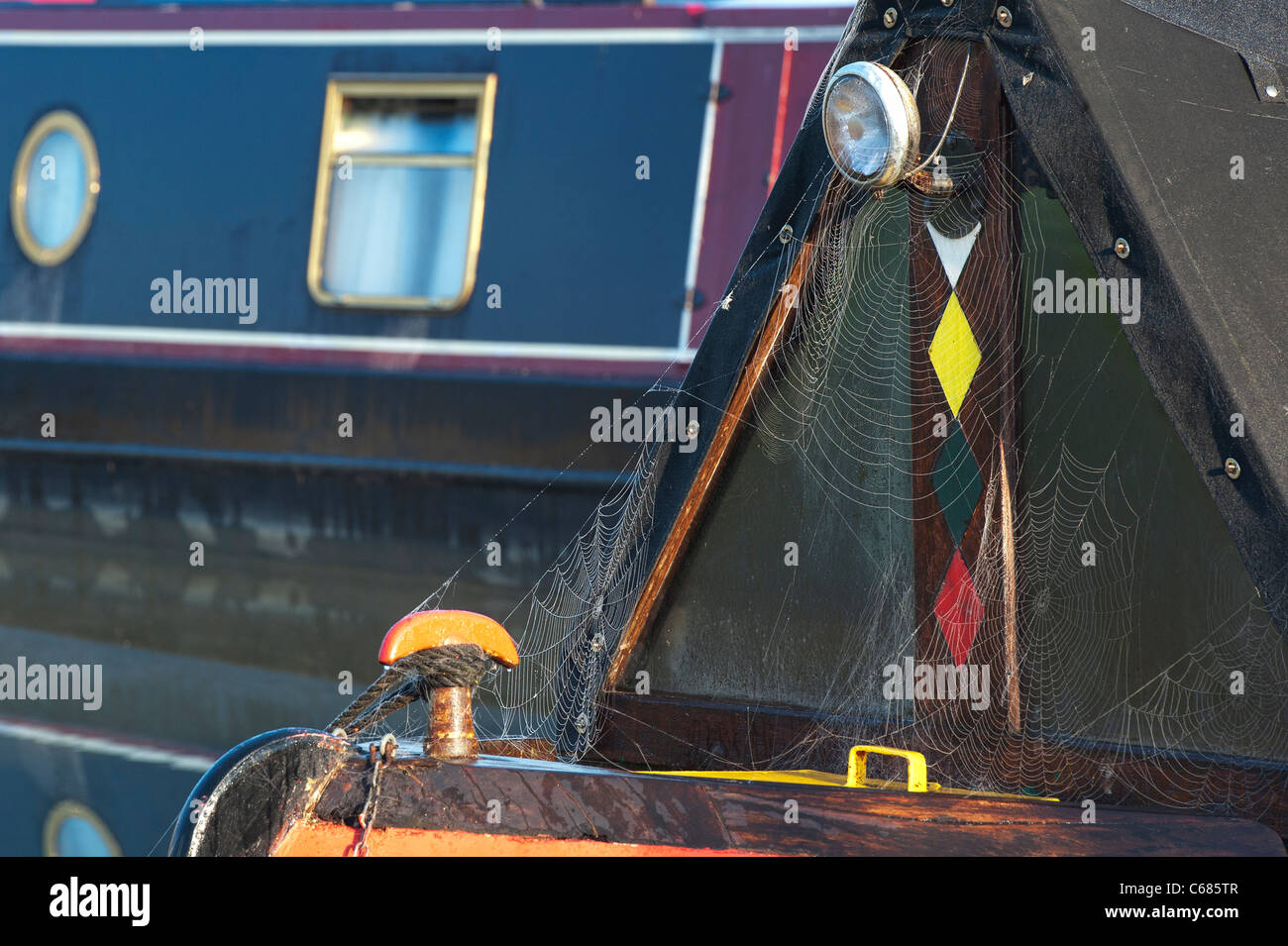 Front light covered in spiders webs on a canal boat lit up by the ...