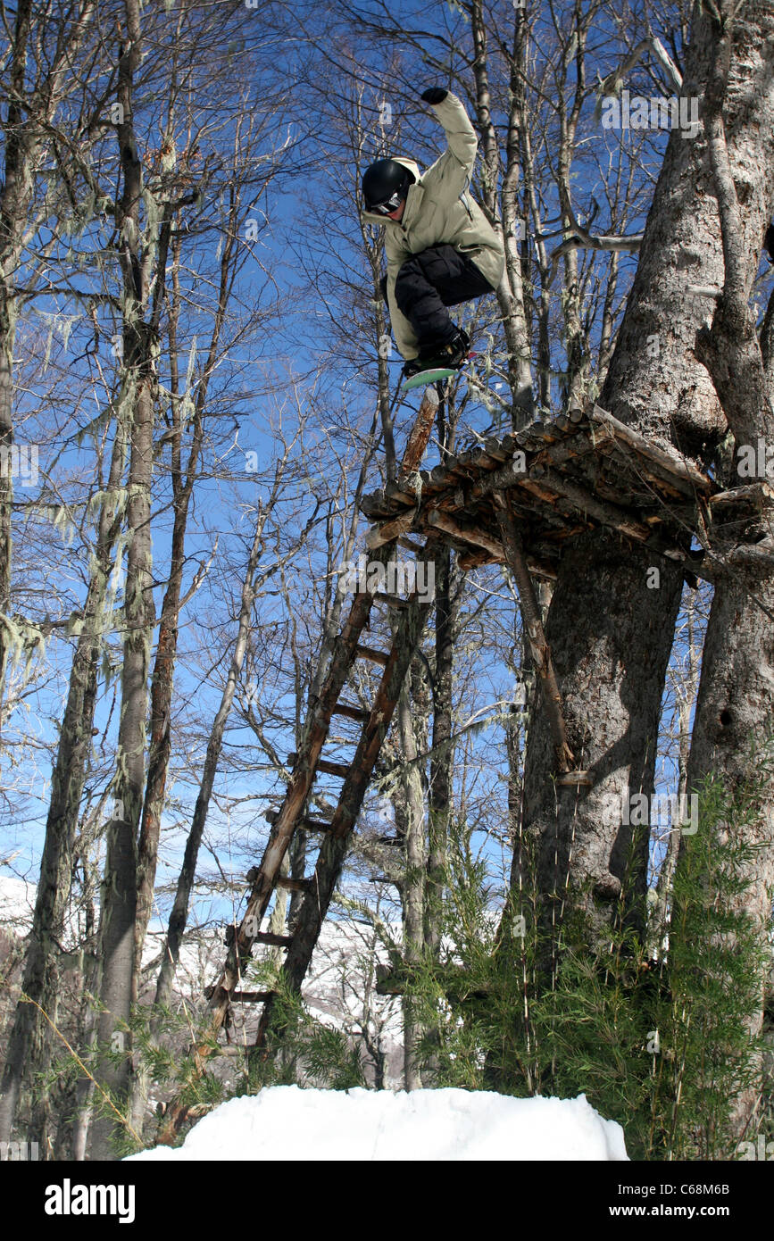 Snowboarder jumping off tree fort at Termas de Chillan ski resort ...