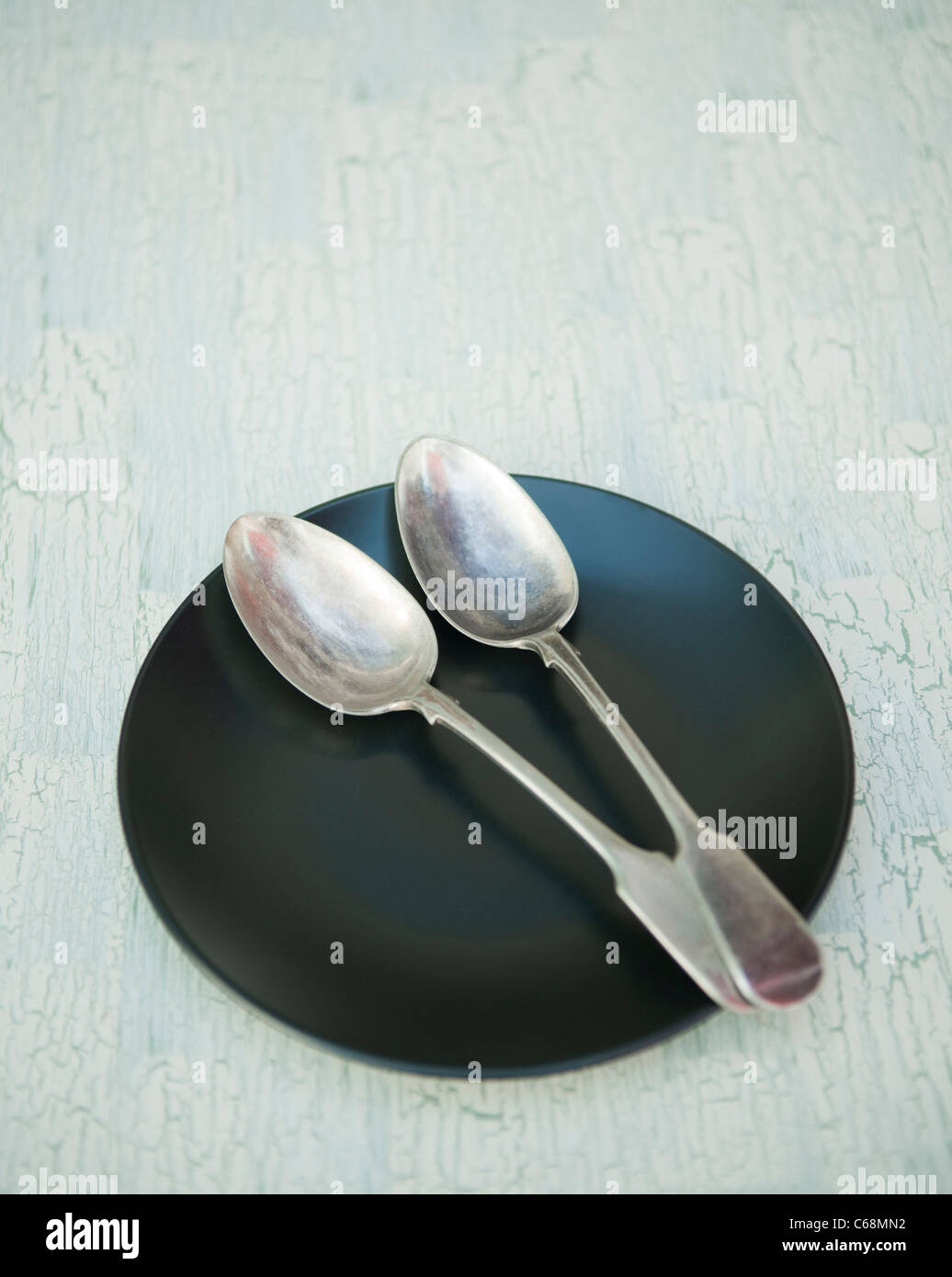 Two spoons on a plate Stock Photo - Alamy