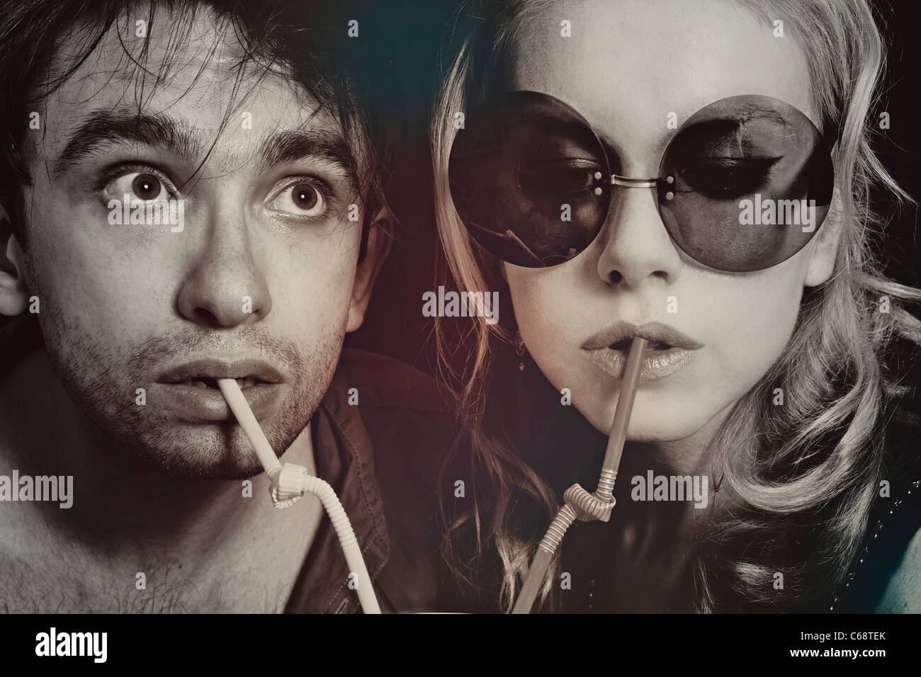 Young man and woman drinking through a tube Stock Photo - Alamy