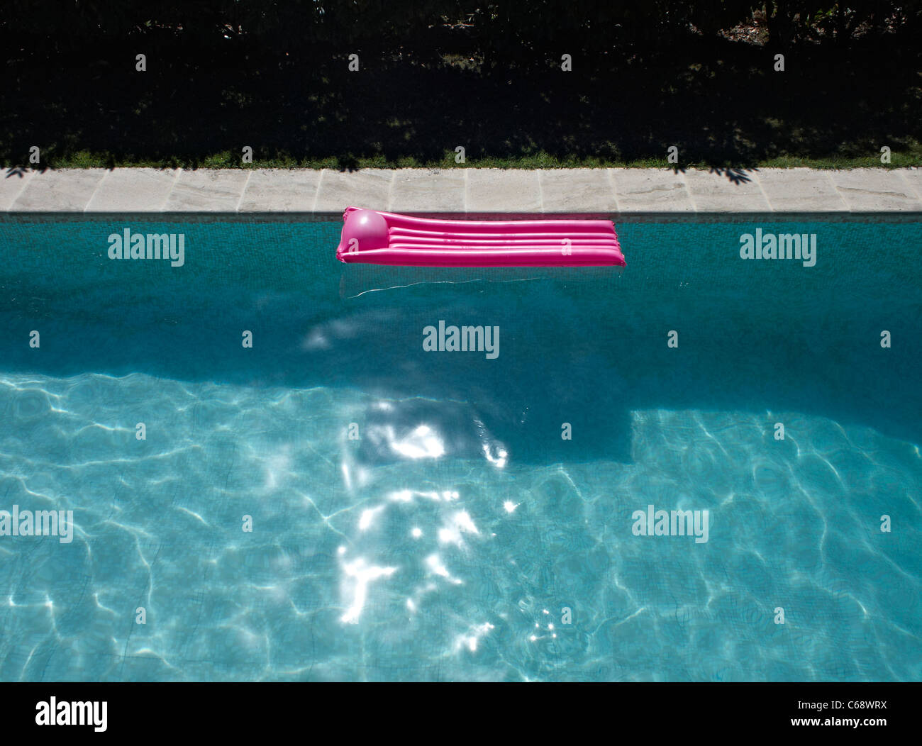 Pink Lilo on sunlit pool, Cote de Azure, France Stock Photo - Alamy