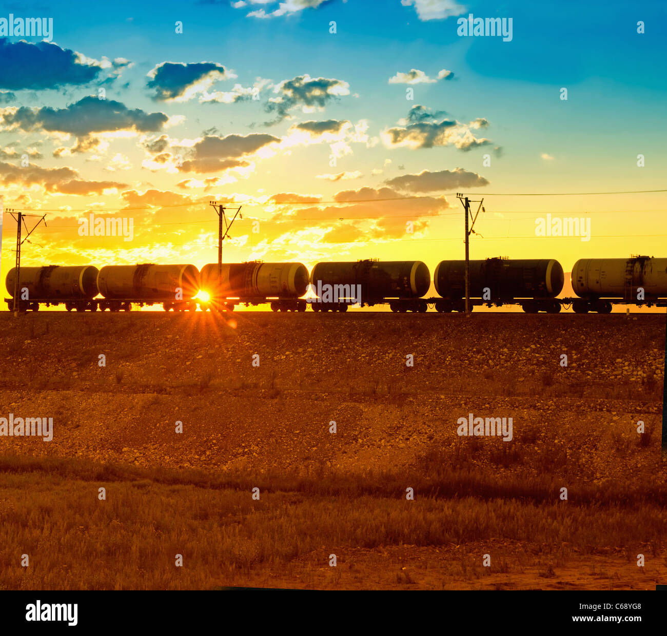 Freight train passing by on sanset beam Stock Photo - Alamy