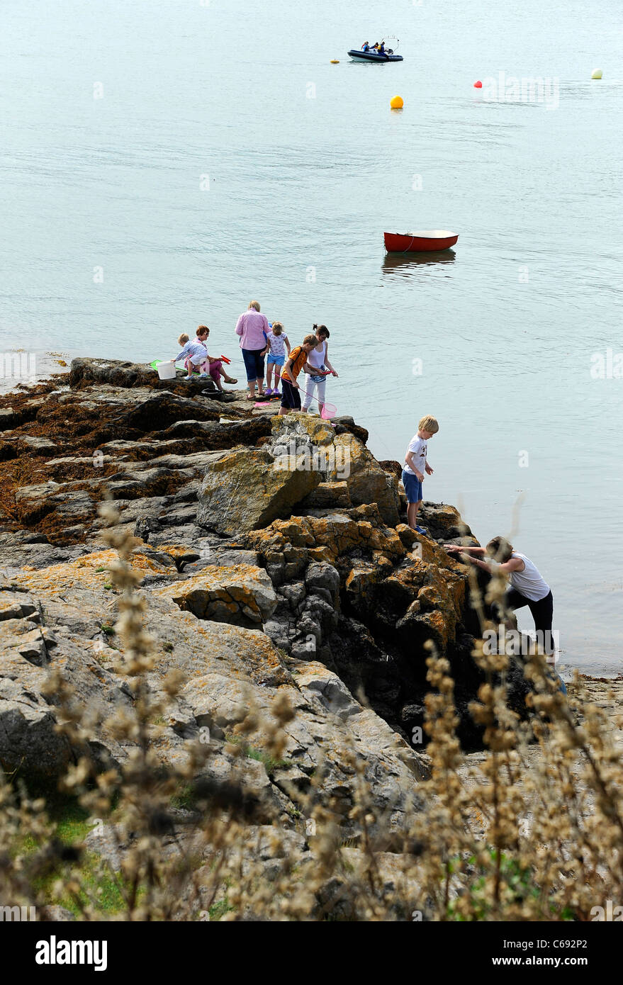 Holidaymakers exploring the rocky coves between Lligwy Bay and Moelfre ...