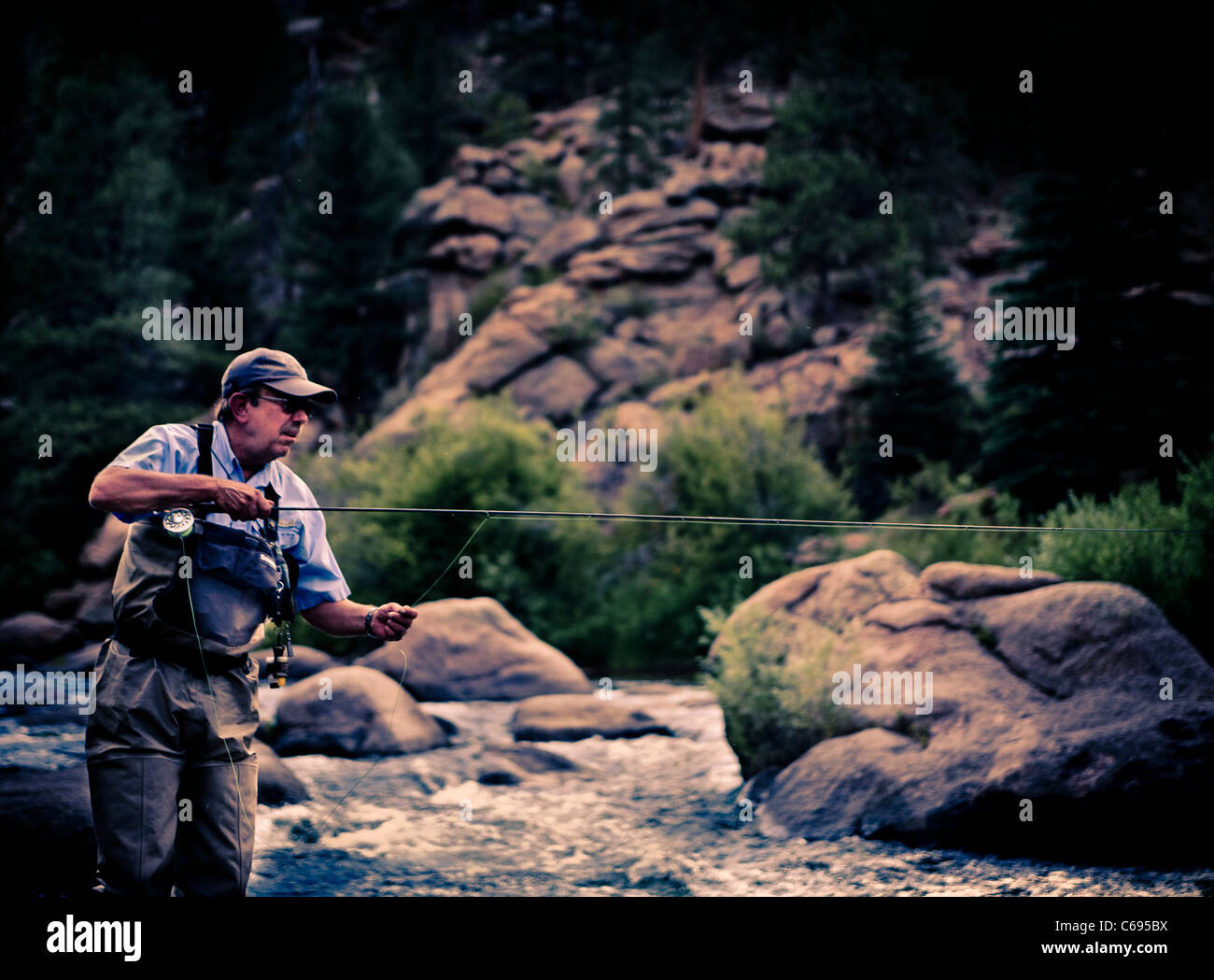 A man enjoying fishing in a river Stock Photo - Alamy