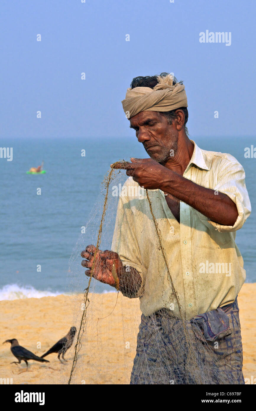 Portrait fisherman sorting fishing nets on Marari Beach Kerala South ...
