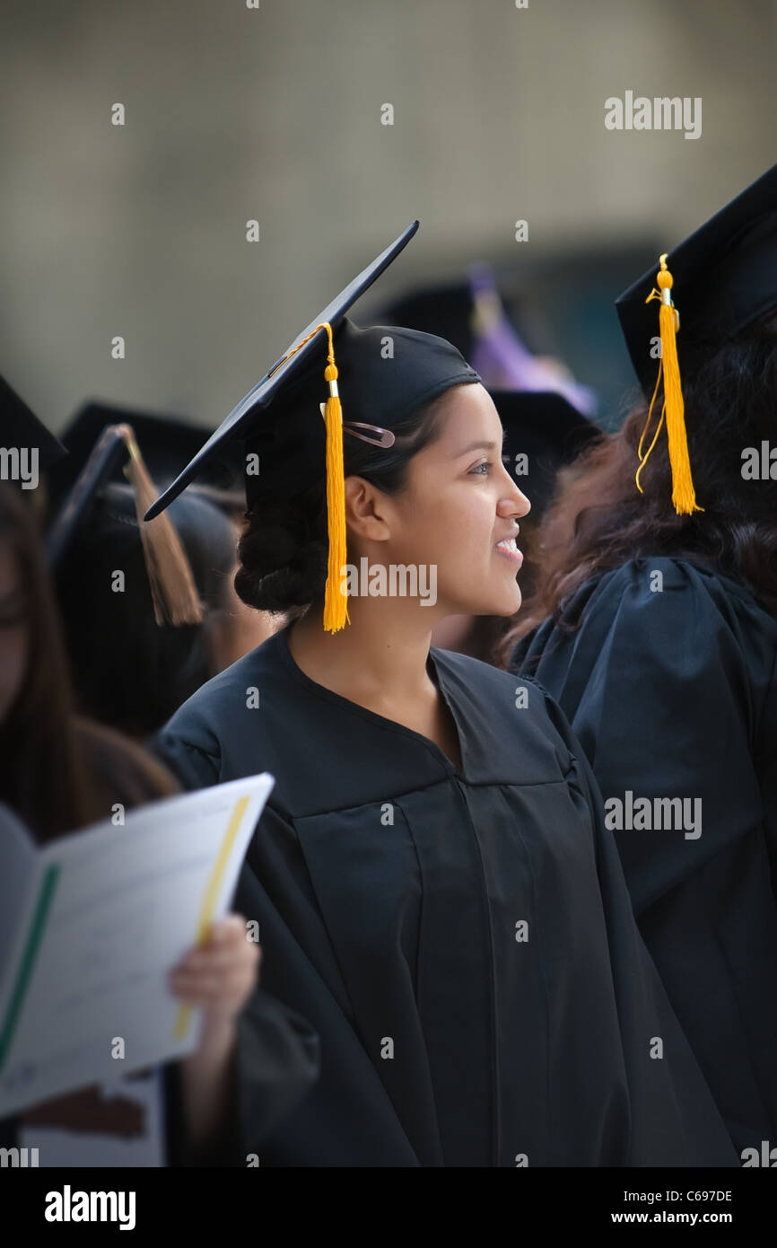 Hispanic or latino young woman wearing graduation hat and gown during ...