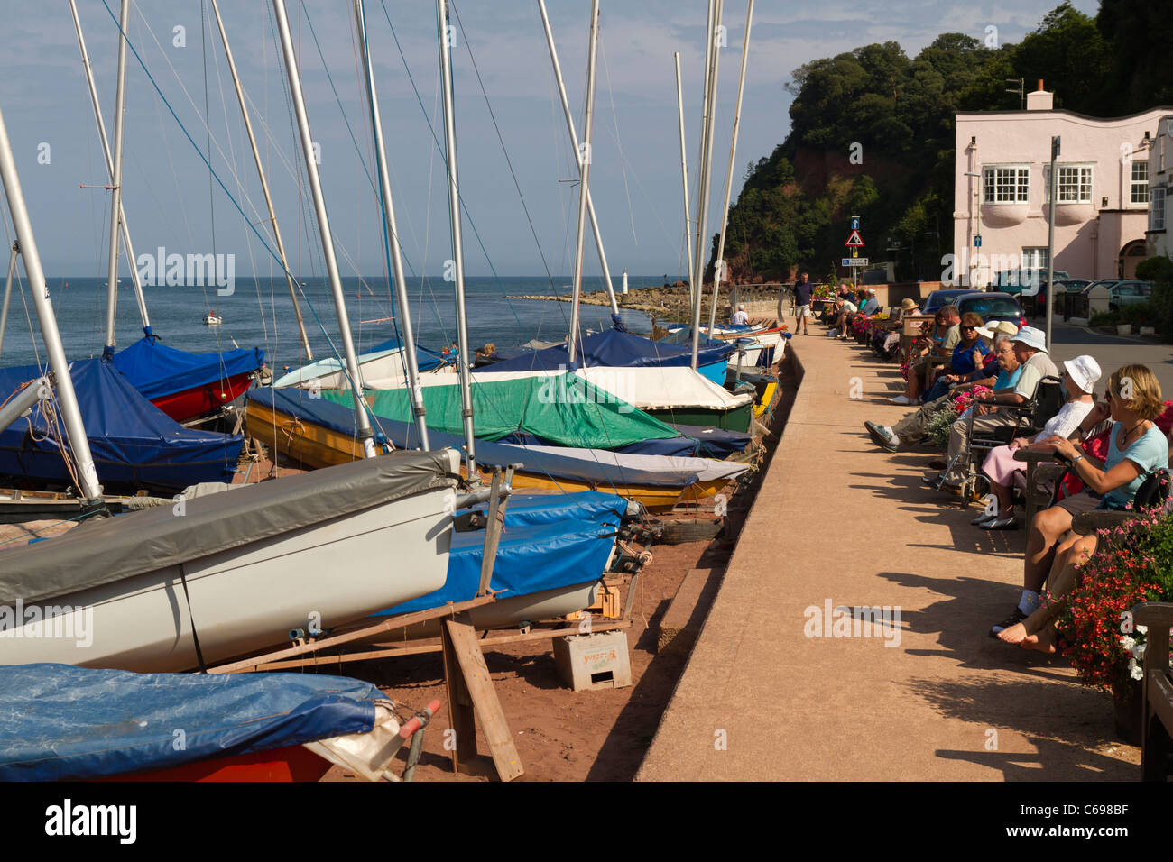 People sitting along the seafront in Shaldon Devon Stock Photo - Alamy