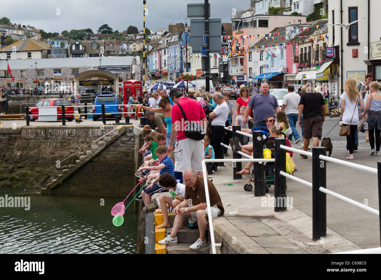 Crabbing on the quayside in Brixham harbour Stock Photo - Alamy