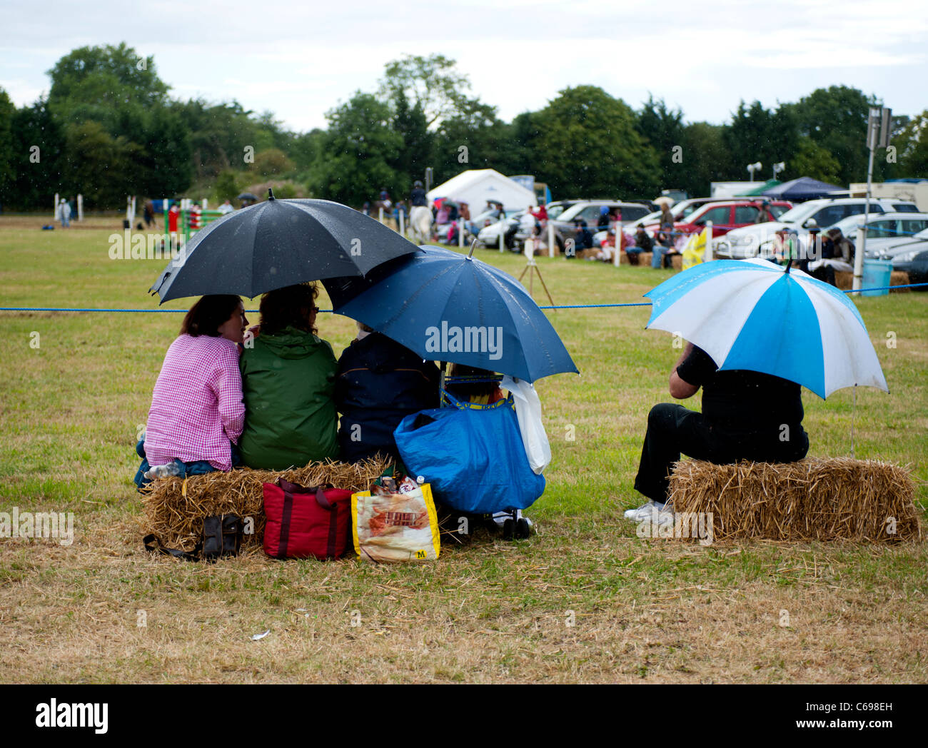 People at an outside event in typical English rainy weather, with ...