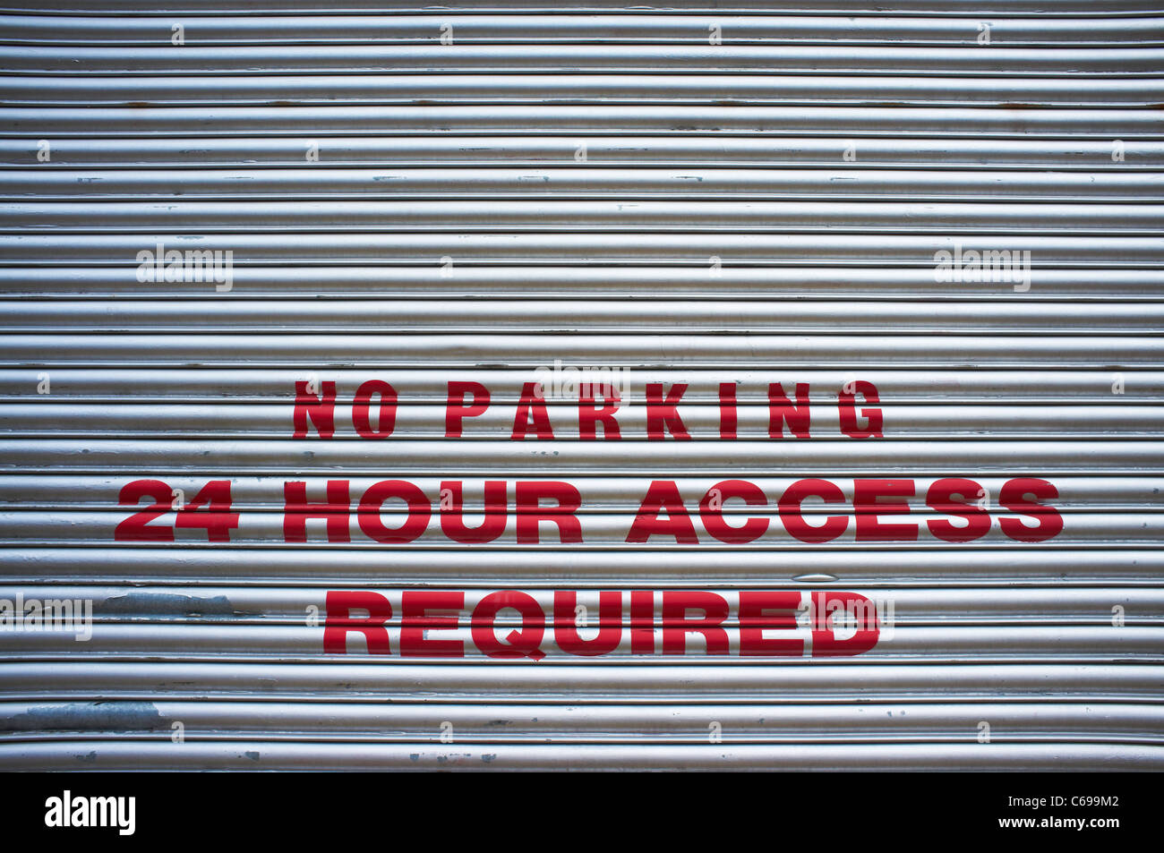 No Parking 24 Access Required sign painted on a shuttered garage door ...