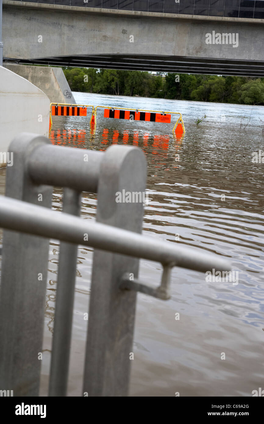 pedestrian walkway steps down into the red river in flood at the forks ...