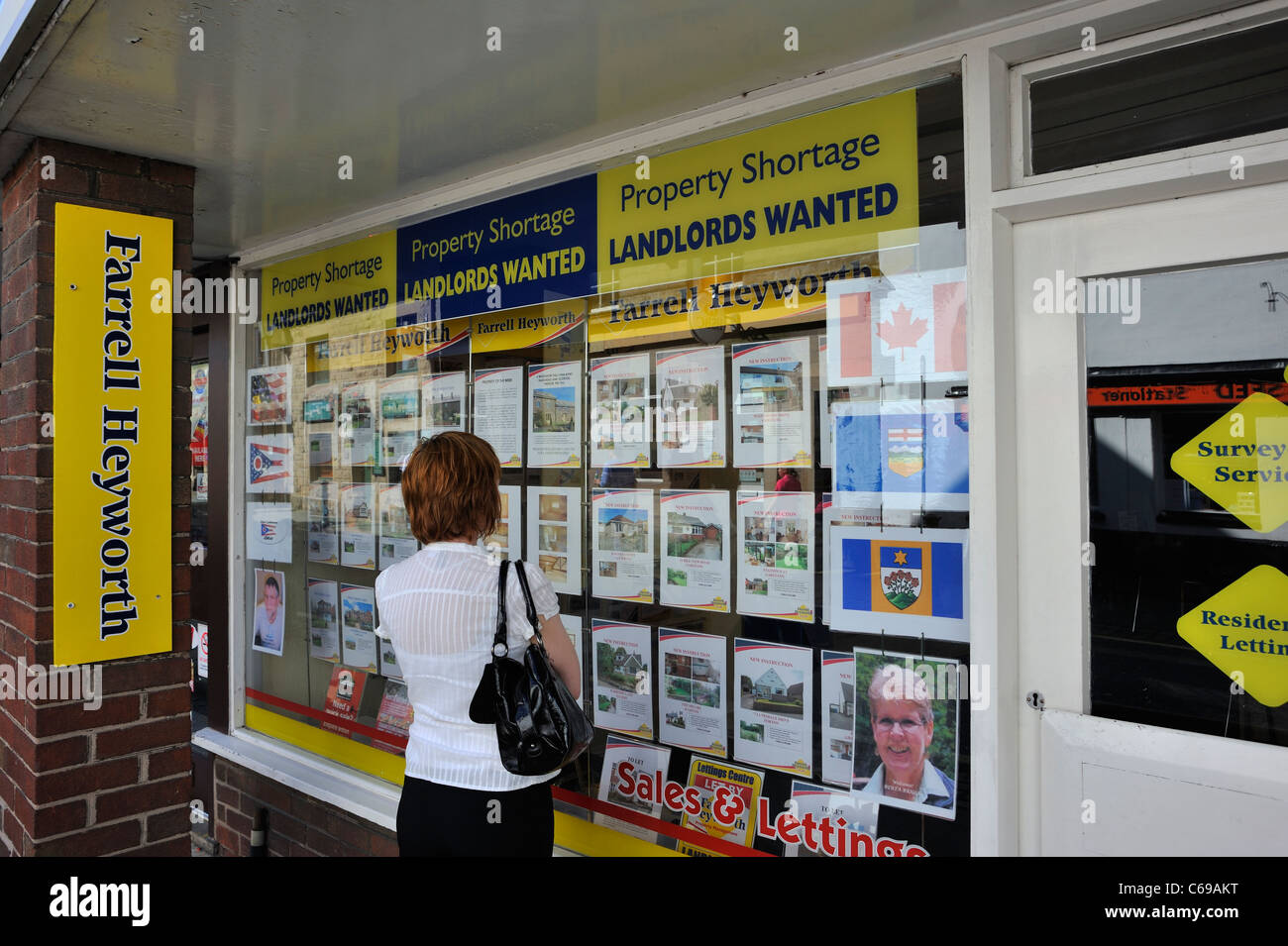 A Woman viewing property in an estate agents window Stock Photo - Alamy