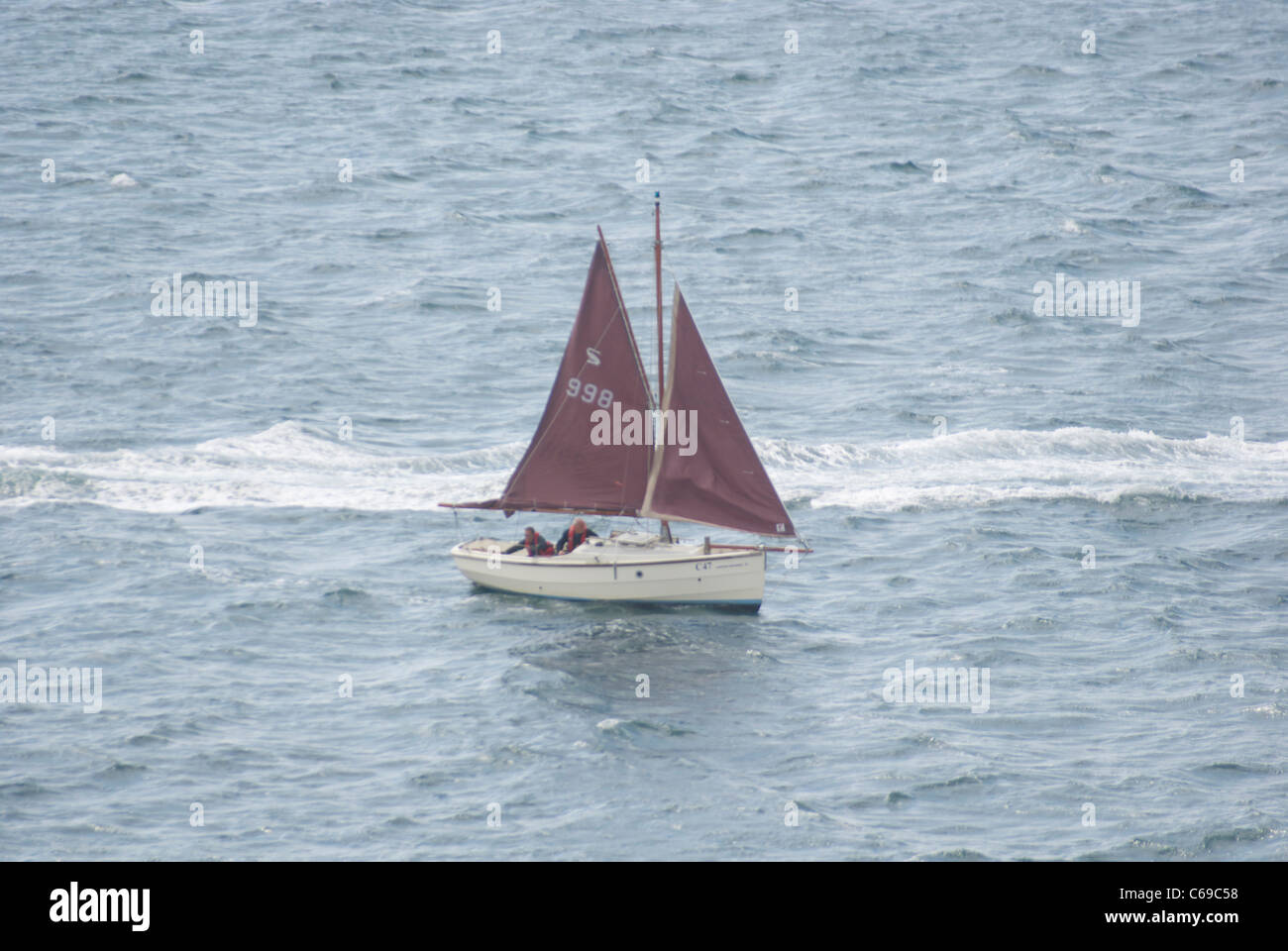 Sailing ship with dark red or maroon sails in the water near Falmouth ...