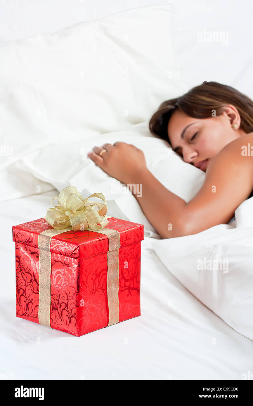 Asleep woman has a surprise present waiting for her in bed Stock Photo ...