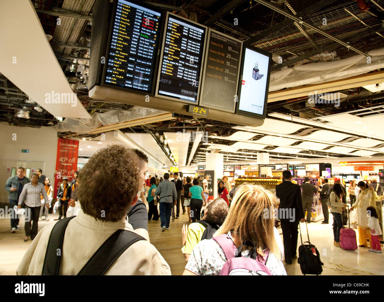 A couple looking at the departures board, Terminal 3, Heathrow airport ...