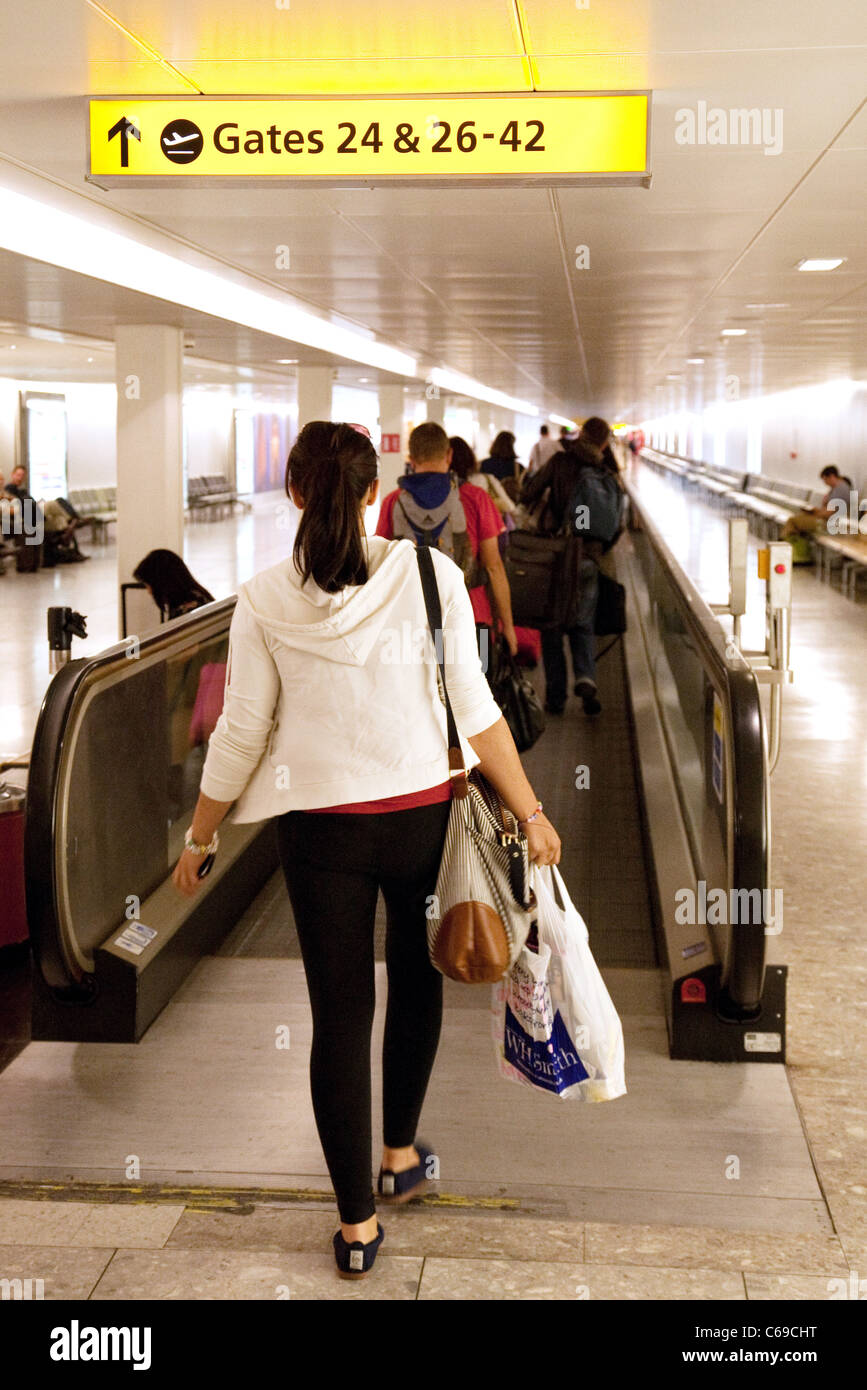 A young woman going to her gate for her flight, Terminal 3, Heathrow ...