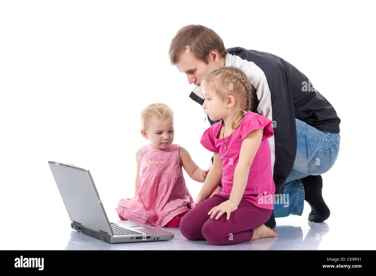 Father with children playing computer games on laptop against white ...