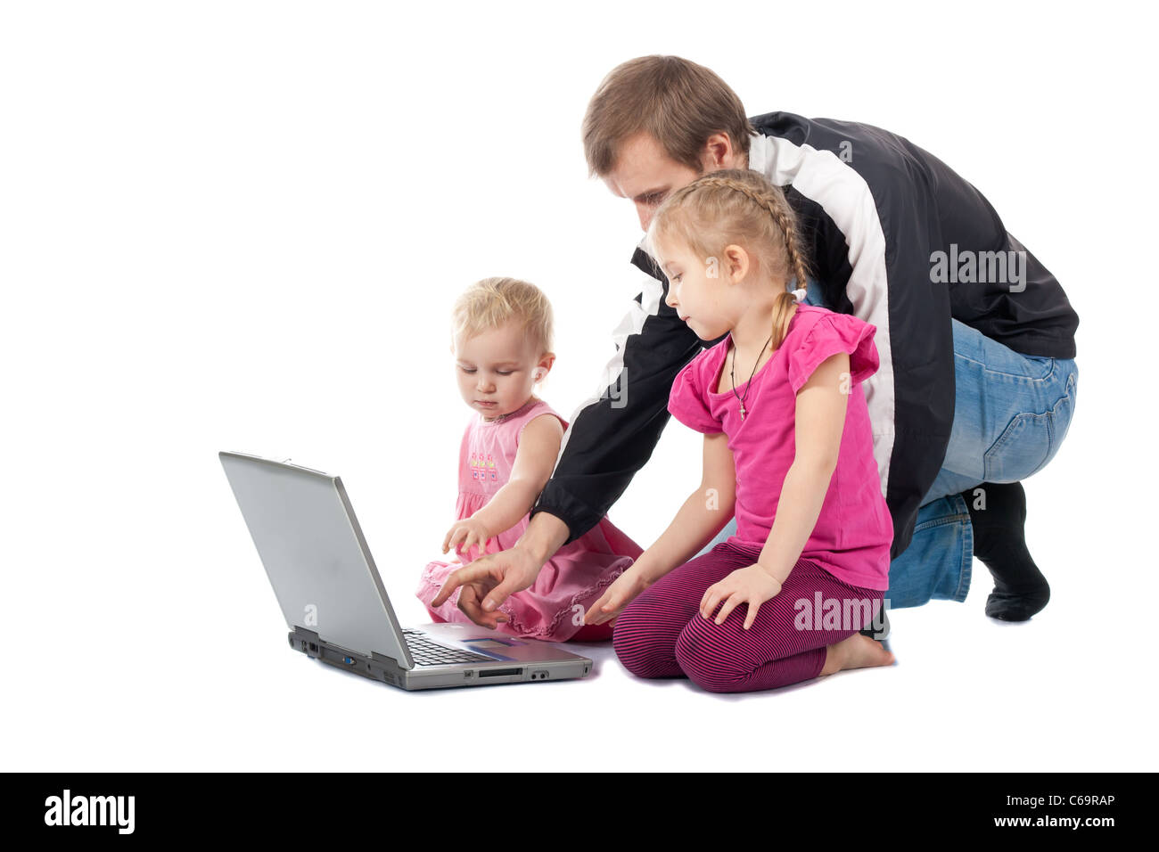 Father with children playing computer games on laptop against white ...