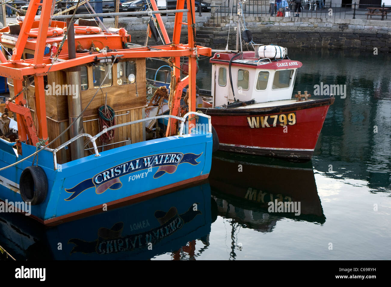 Two fishing boats reflected in the water at Sutton Harbour, Barbican ...