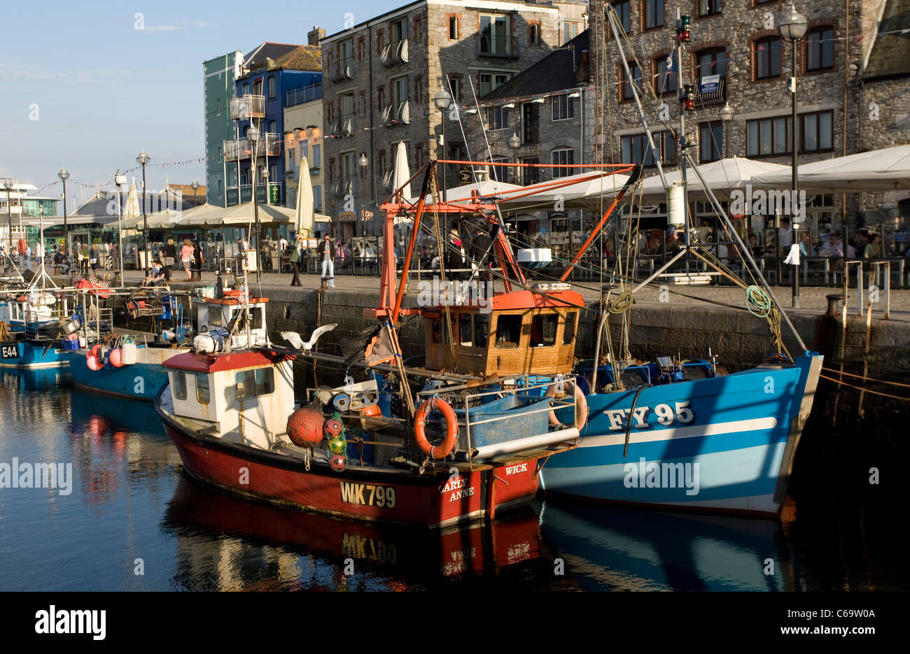 Red and blue fishing boats in Sutton Harbour on the Barbican, Plymouth ...