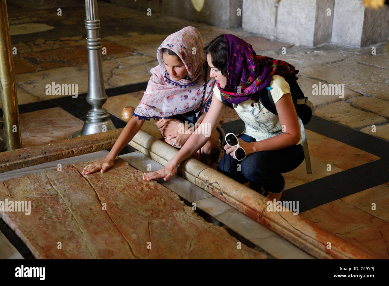 Christian pilgrims pray over the Stone of the Anointing or Stone of ...