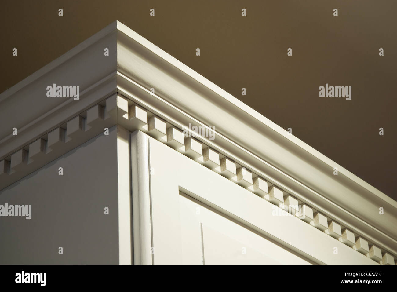 The top crown moulding dentil detail on some creme-color painted solid ...