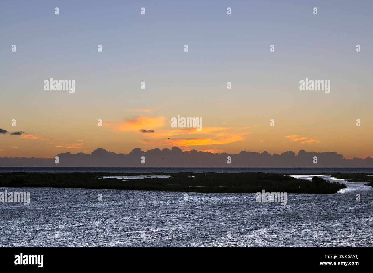 Sunrise. Ebro river at its base level, in front to the sea coast ...