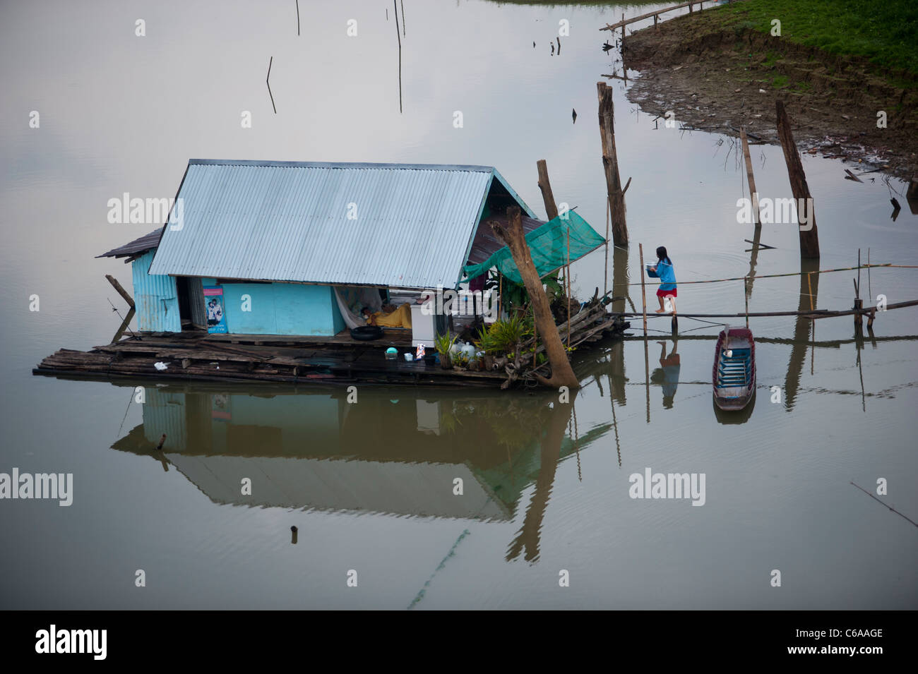 House chores on board a wooden floating family home along the banks of ...