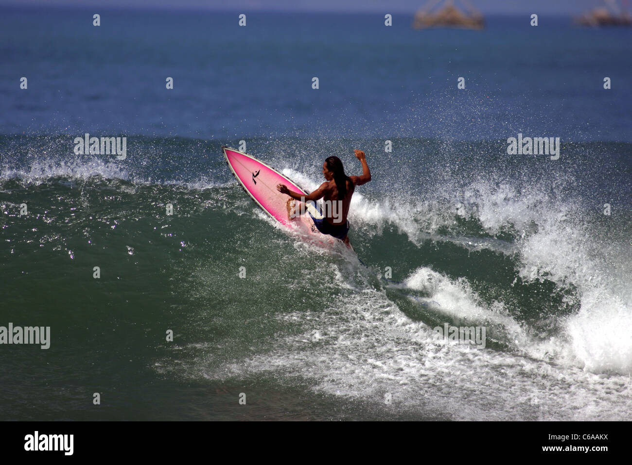Local surfer rides a wave at Cimaja in West Java, Indonesia Stock Photo ...