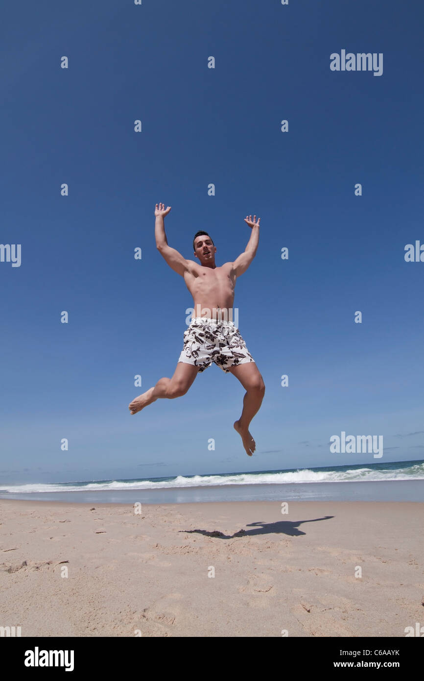 Young man jumping in water at beach hi-res stock photography and images ...