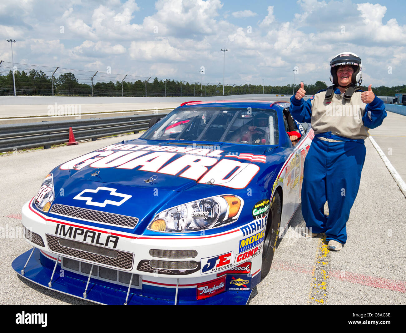Woman about to ride around race track at 150 mph with race driver in ...